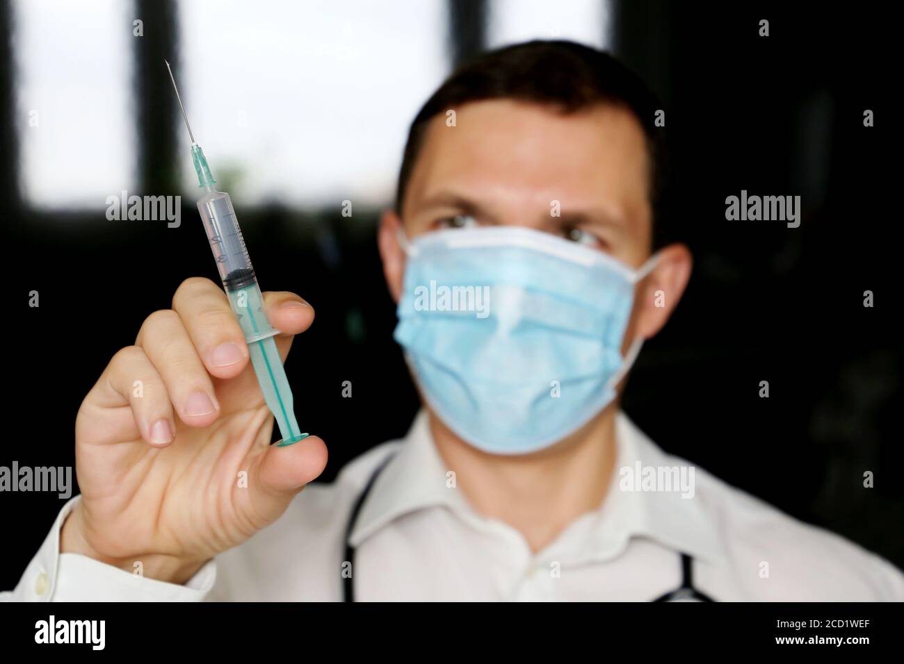 Doctor with syringe, man in medical mask preparing to injection ...