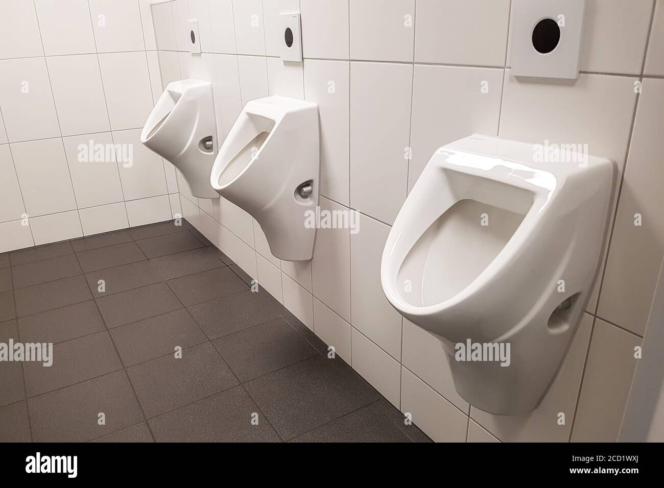 Row of urinals in a public toilet Stock Photo - Alamy