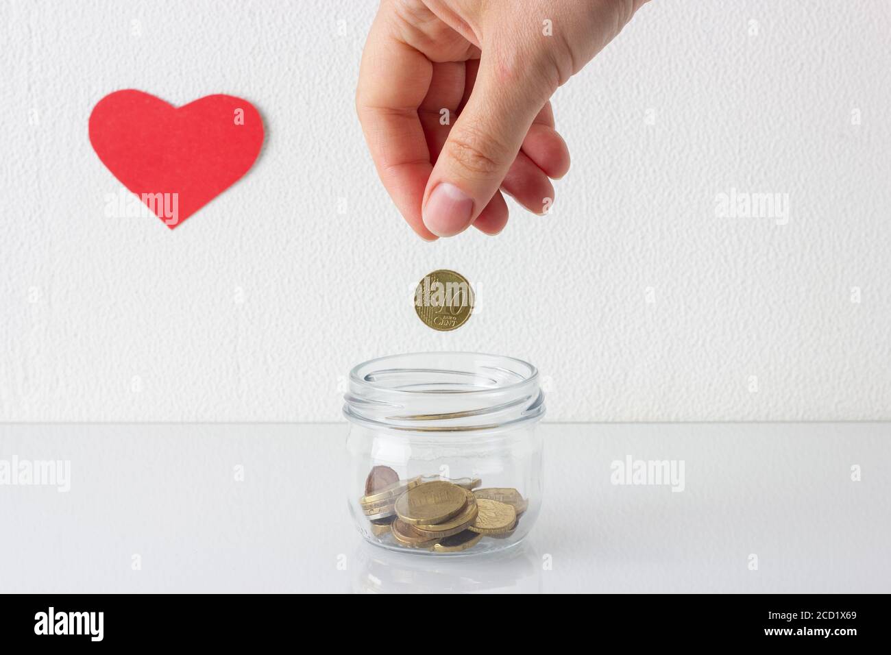 Hand putting coin in a jar on white background. Saving money, medicine ...