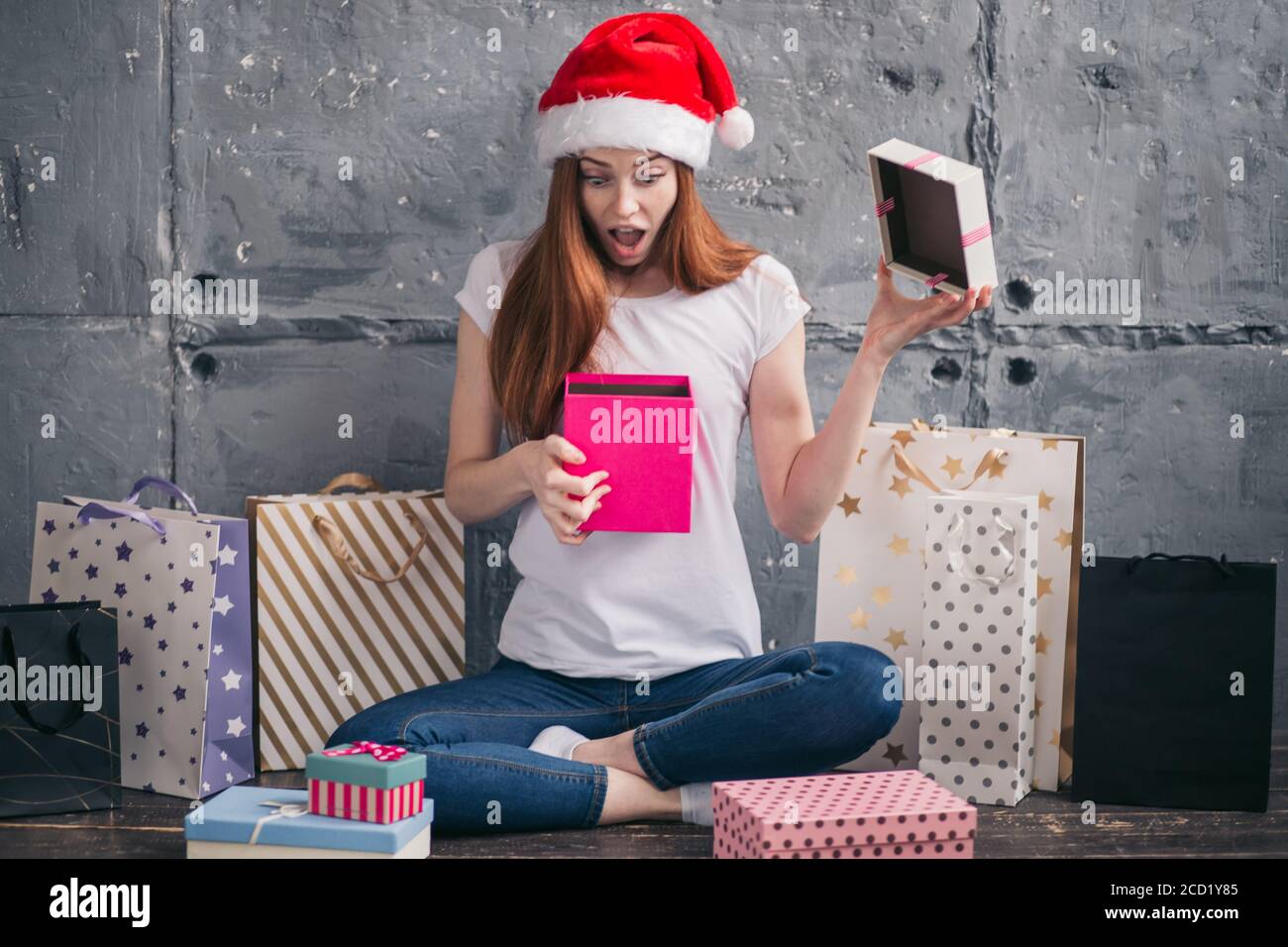 frustrated shocked girl holding a gift box, awful present. dislike ...