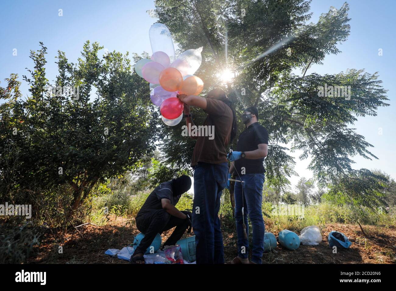 Masked Palestinians attach incendiary devices to balloons before ...