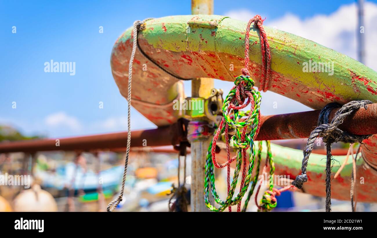 The knots of a rope attached to a tattered life ring at a boat ramp ...