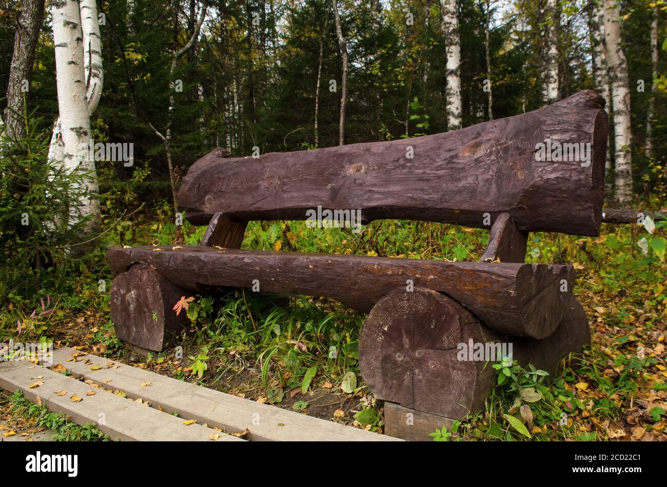 wooden bench made of logs in the autumn Park Stock Photo - Alamy