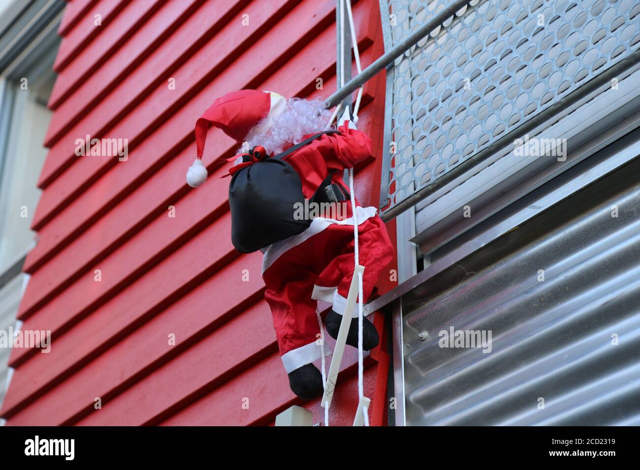 Santa Claus climbing out of the window Stock Photo - Alamy