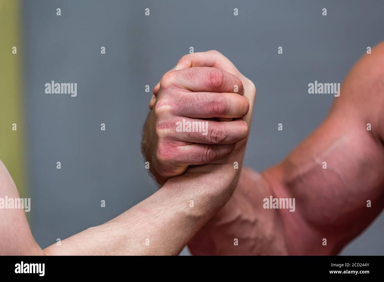 Close-up shot of strong mans' muscles during an arm-wrestling fight ...