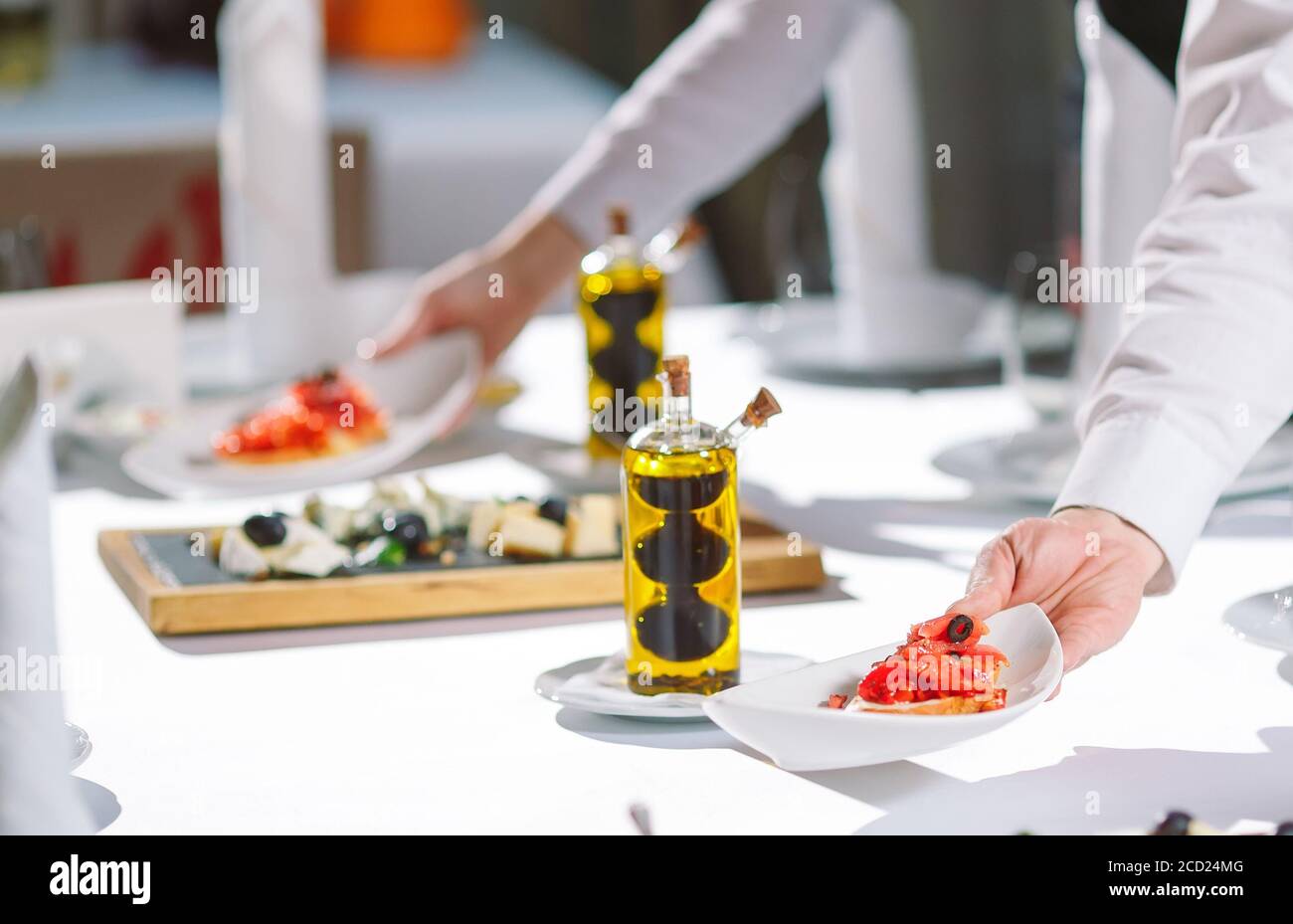 Waiter serving table in the restaurant preparing to receive guests ...