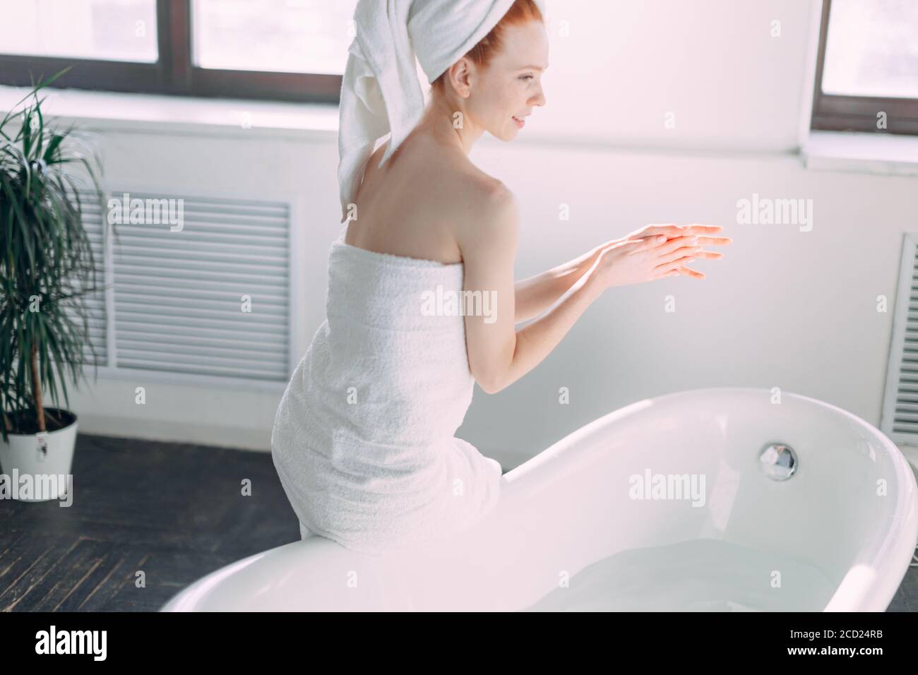 Beautiful woman in bath wear is going to wash her body in the bathtub ...