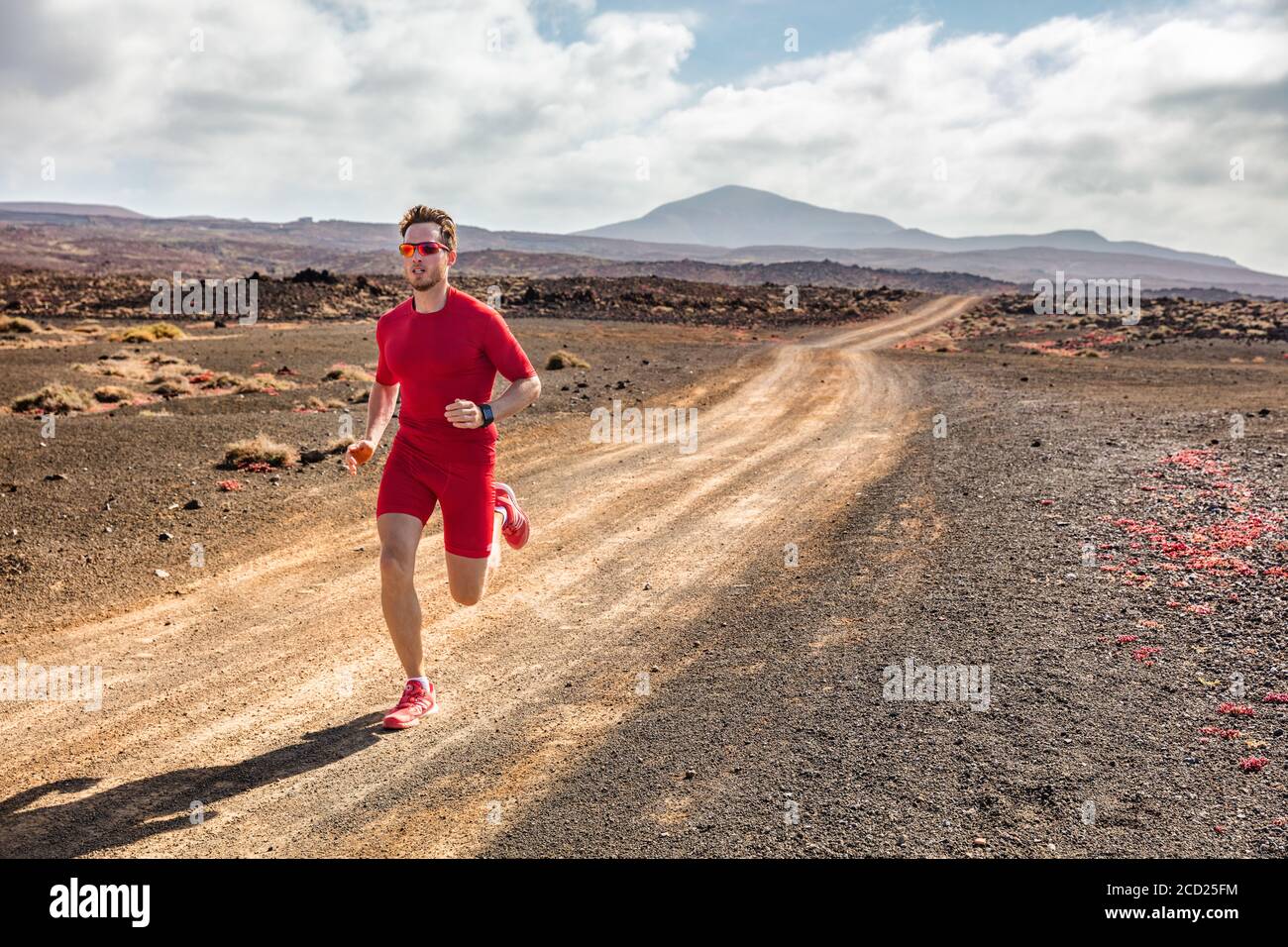 Trail running athlete fitness man runner sprinting on desert dirt road wearing compression ...