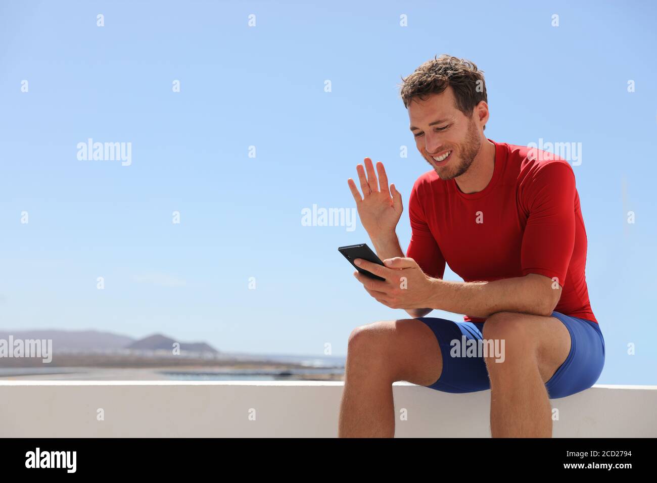 Man calling via video call on phone talking to someone waving hello ...