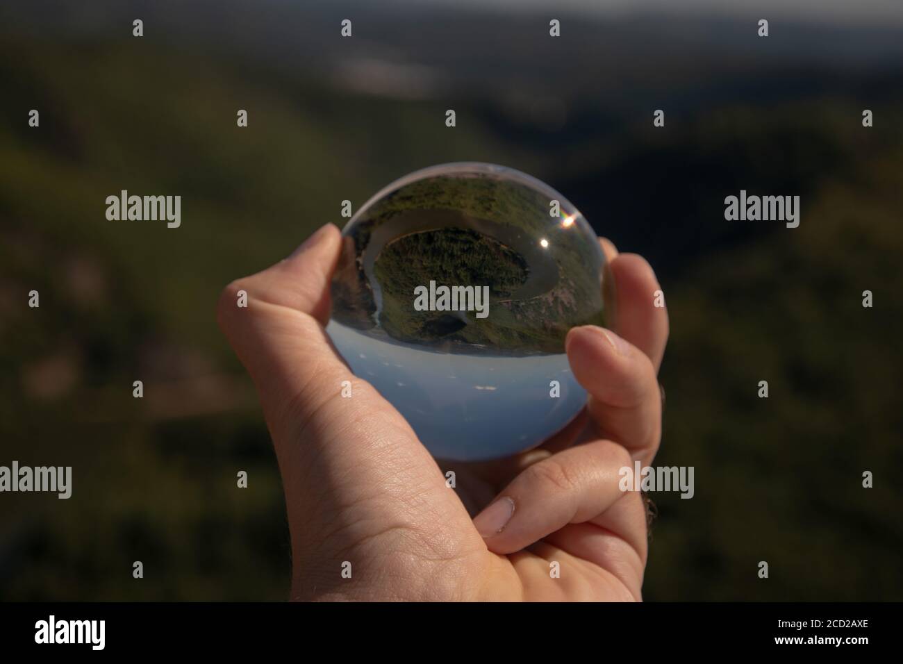 Closeup of a person holding a transparent sphere with the upside-down ...