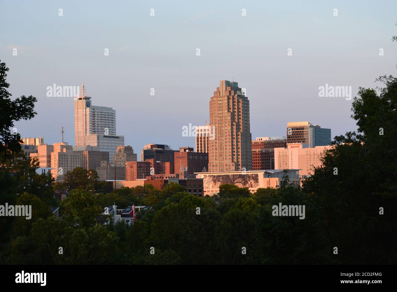 The setting sun highlights the buildings of downtown Raleigh from an ...