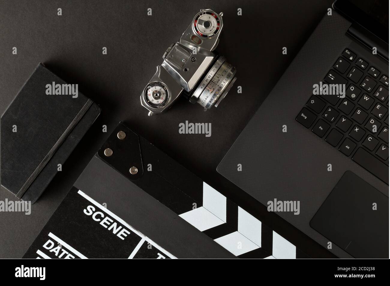 Retro analog SLR camera, movie clapper and notebook next to laptop on ...