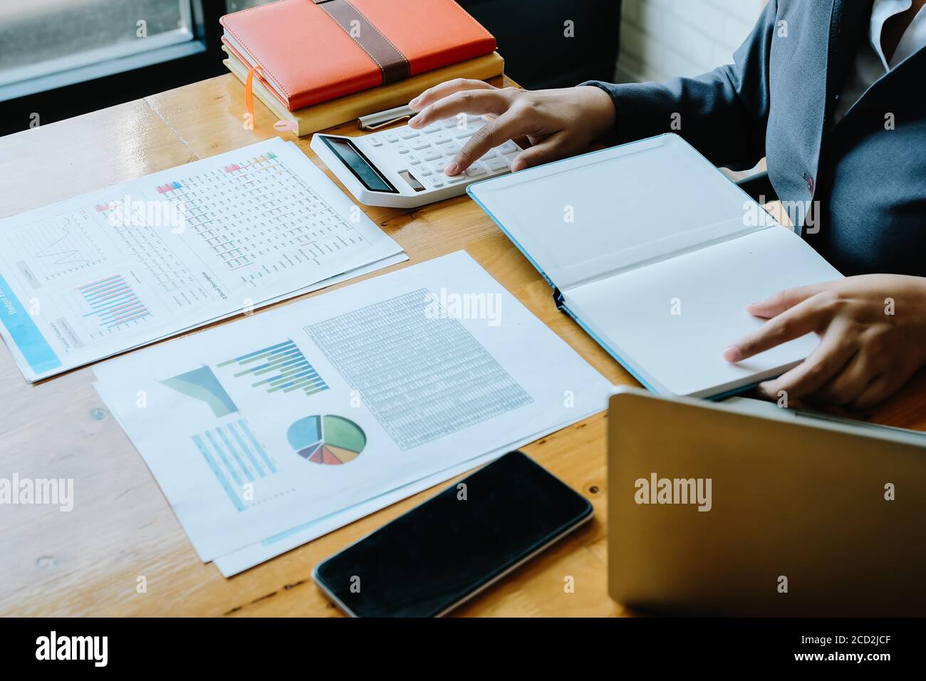 Business woman using calculator for do math finance on wooden desk in ...
