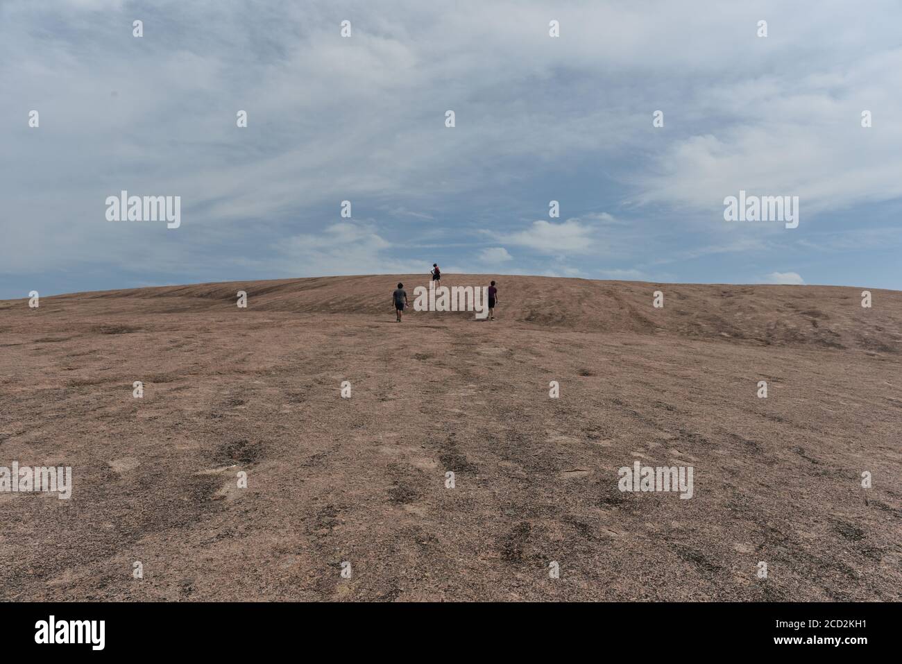 three men on the top of Enchanted Rock Stock Photo - Alamy
