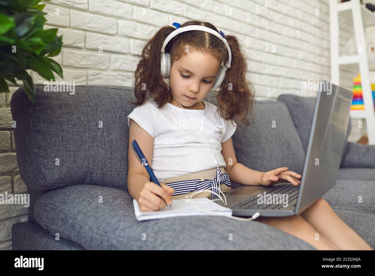 Online education kid. Adorable child in headphones watching video ...