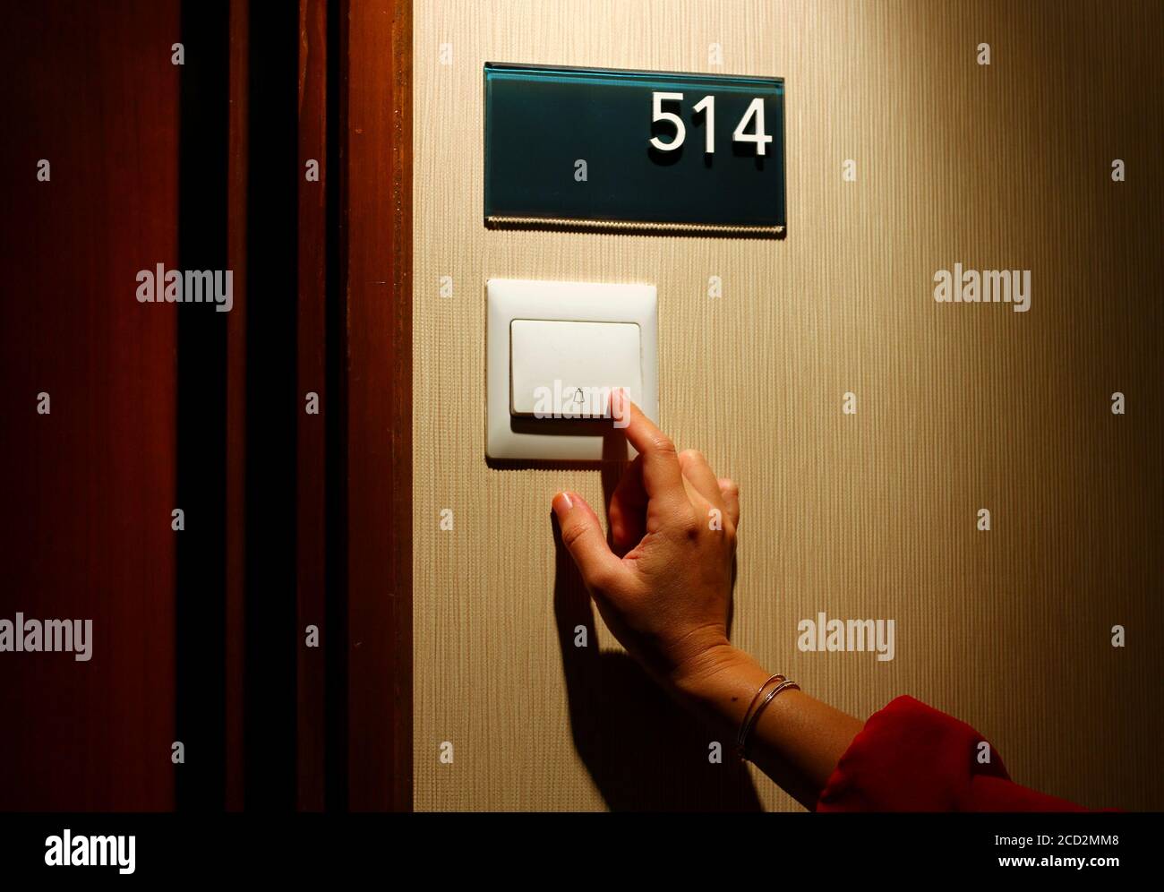 Hand pressing hotel door bell Stock Photo - Alamy