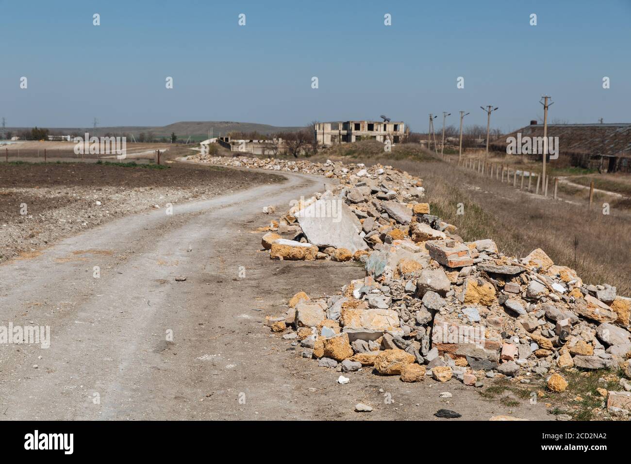 Old construction waste. Heaps of garbage lie along a dirt road ...