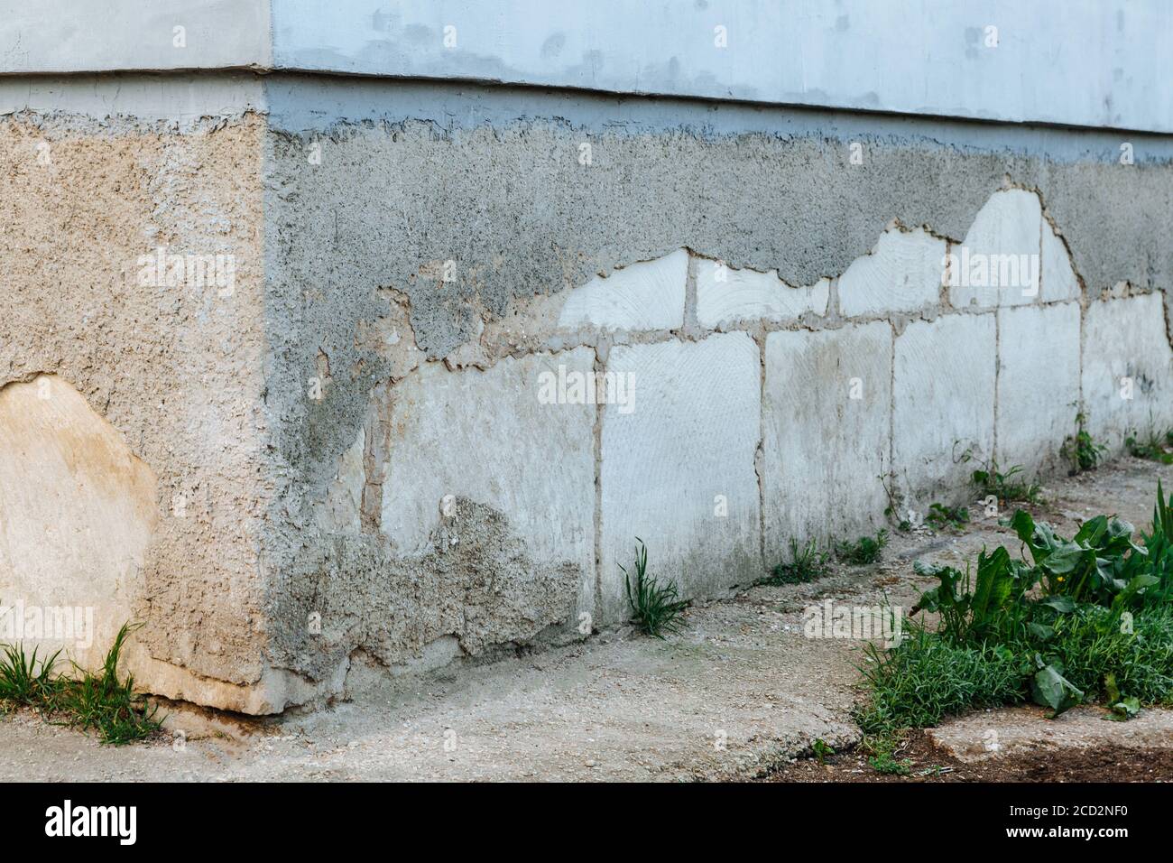 Plaster peeling off brick wall. The foundation of a residential ...