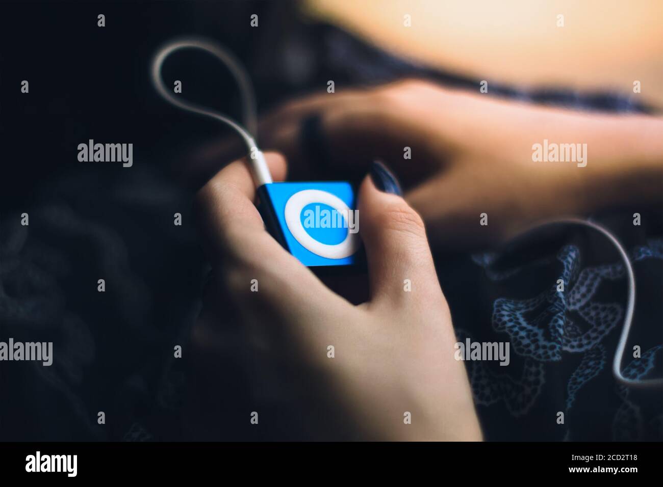 small mp3 player in women's hands on dark background, soft focus Stock ...