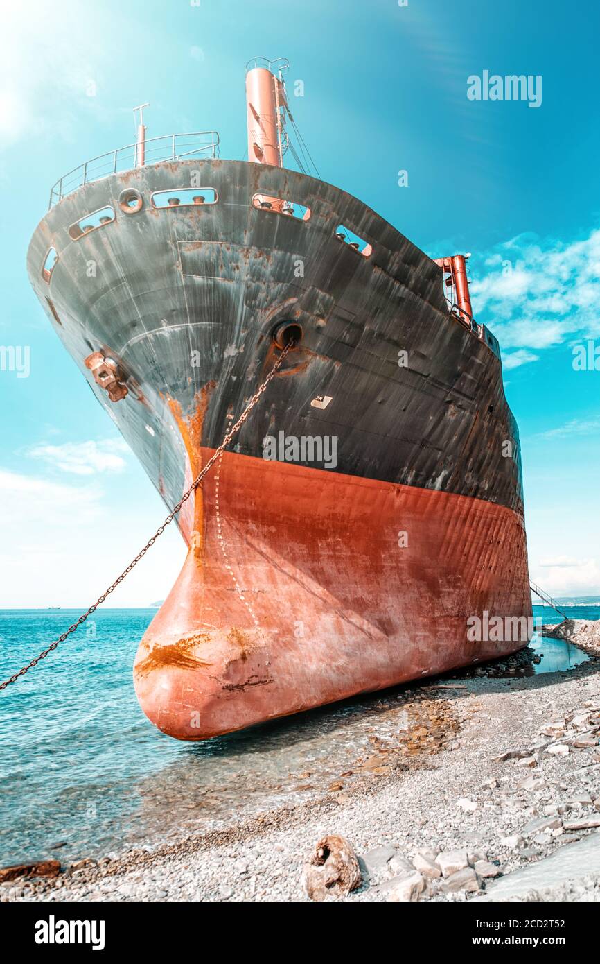 An old black-and-red ship that anchored and ran aground. The bow of the ...
