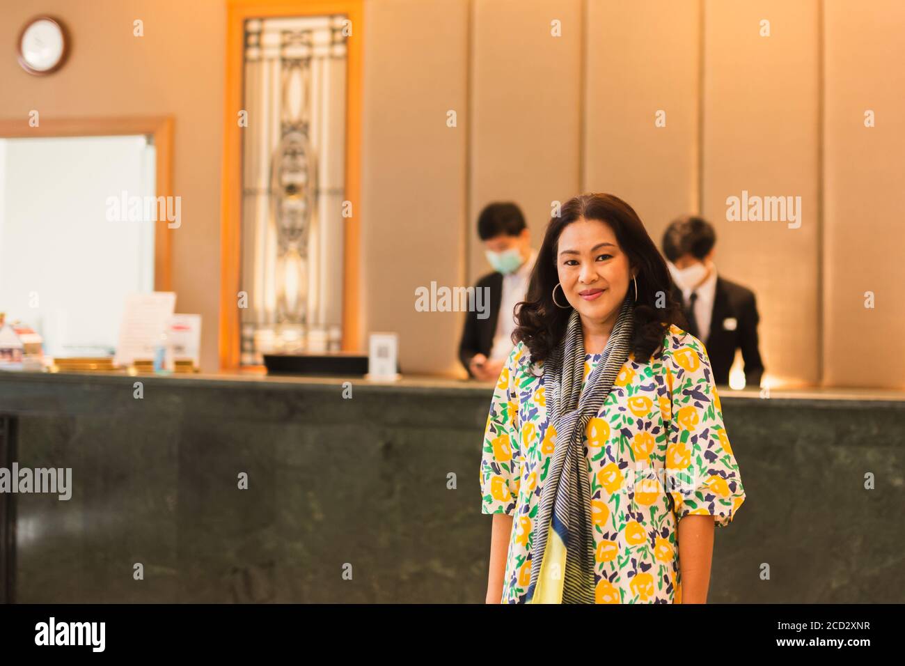 Woman in beautiful dress standing on front of hotel reception Stock ...