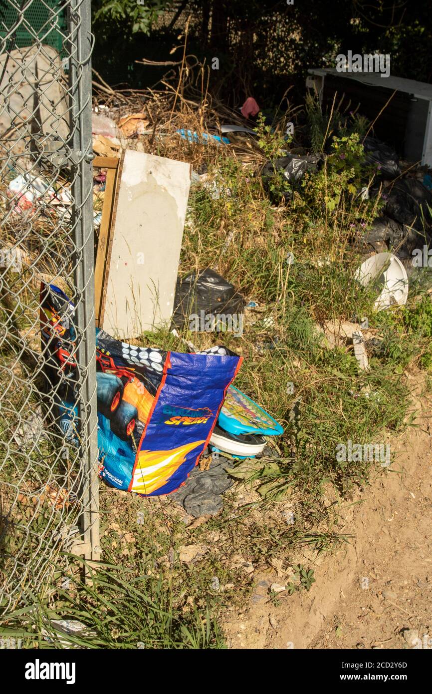 Casually discarded household waste littering an alleyway, environmental ...