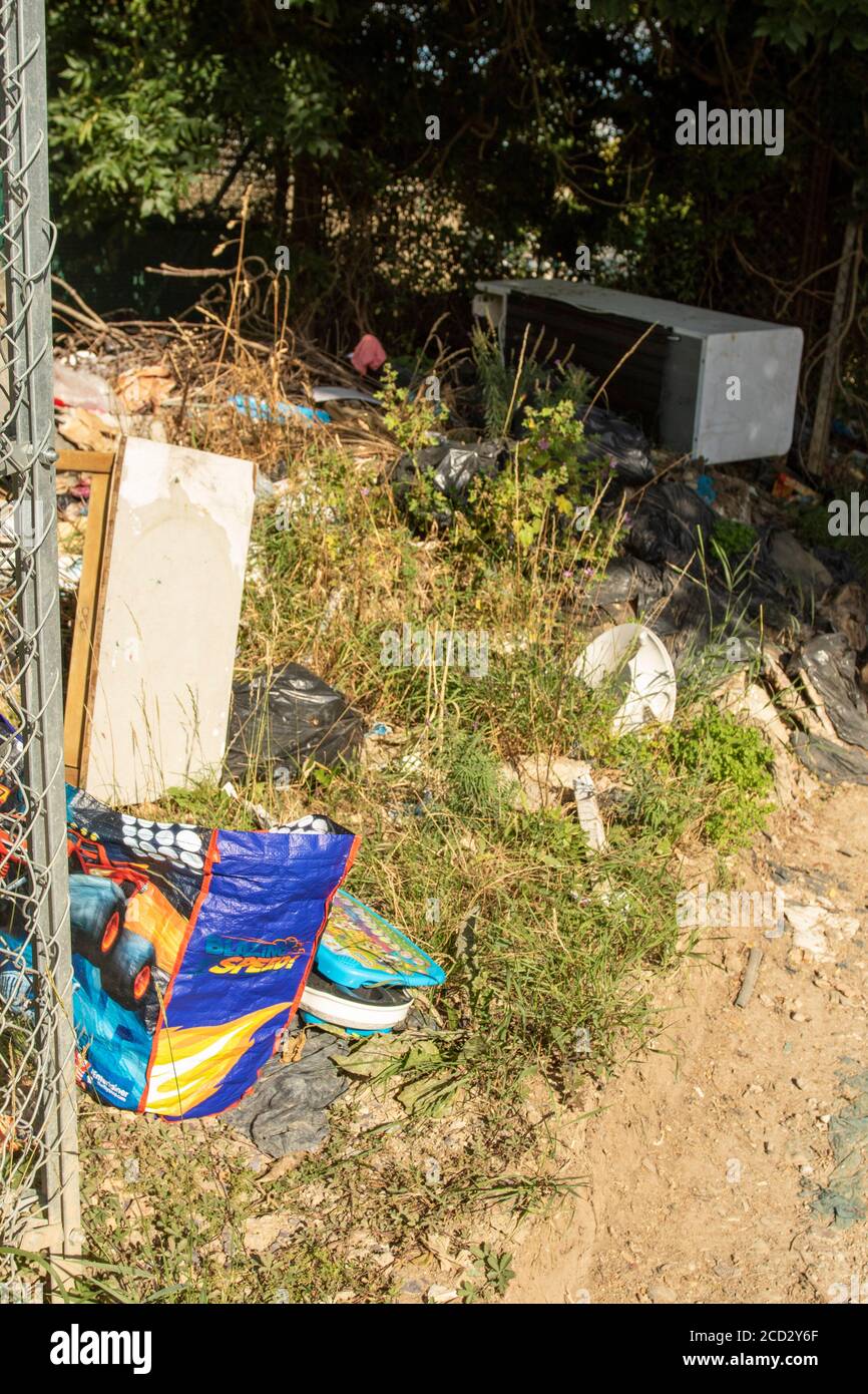 Casually discarded household waste littering an alleyway, environmental ...