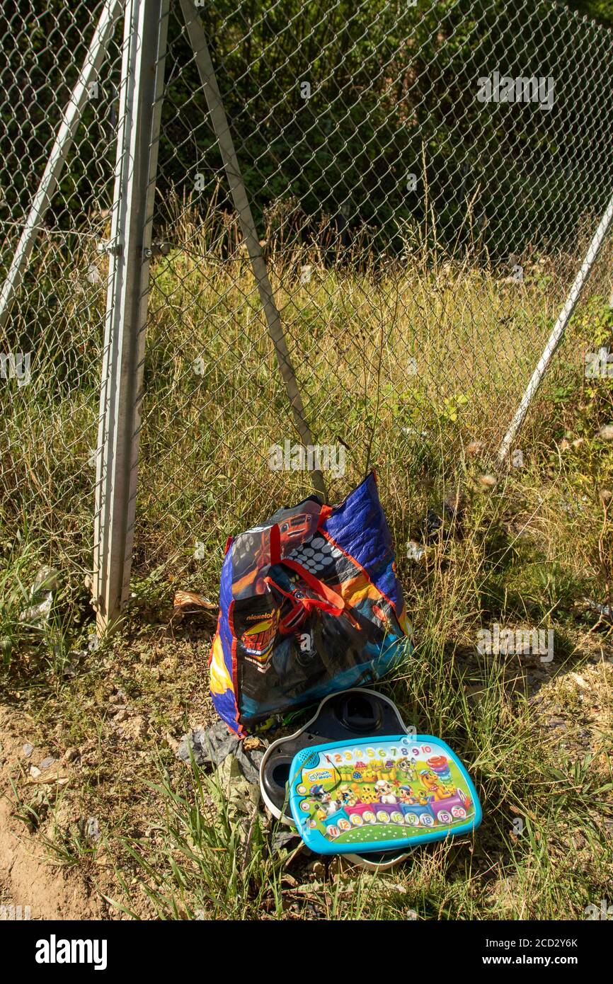 Casually discarded household waste littering an alleyway, environmental ...