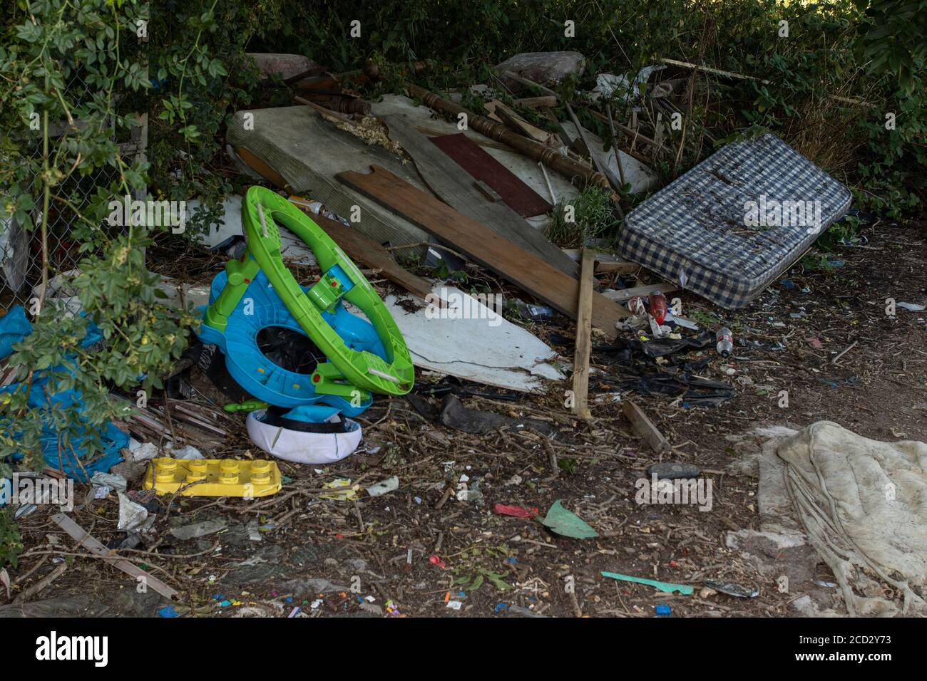 Casually discarded household waste littering an alleyway, environmental ...