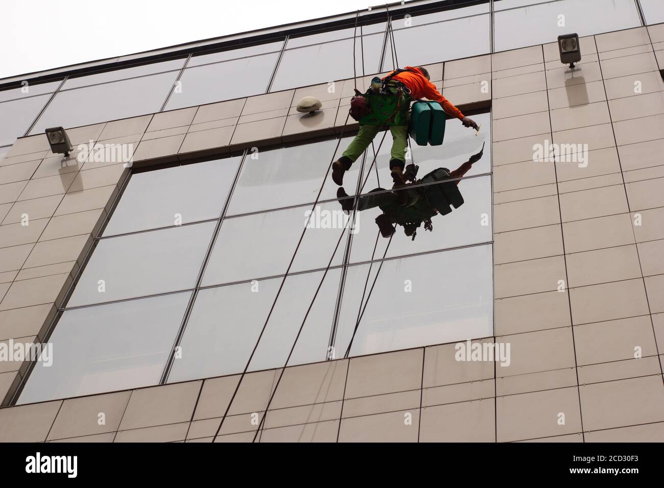 portrait of worker washing windows of the modern building Stock Photo ...