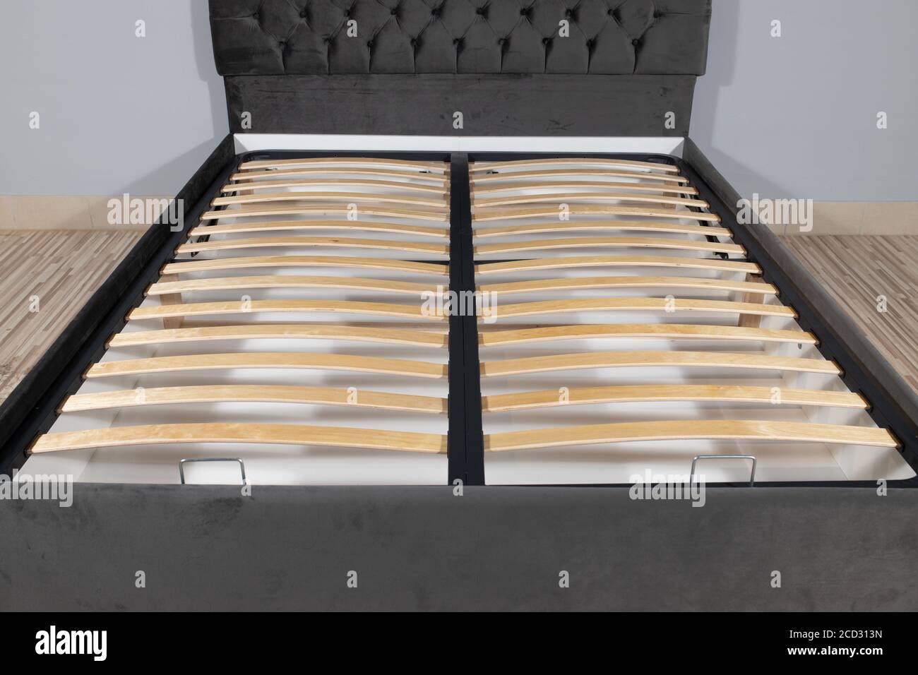 Bed with gray upholstery and without mattress in an empty room Stock ...