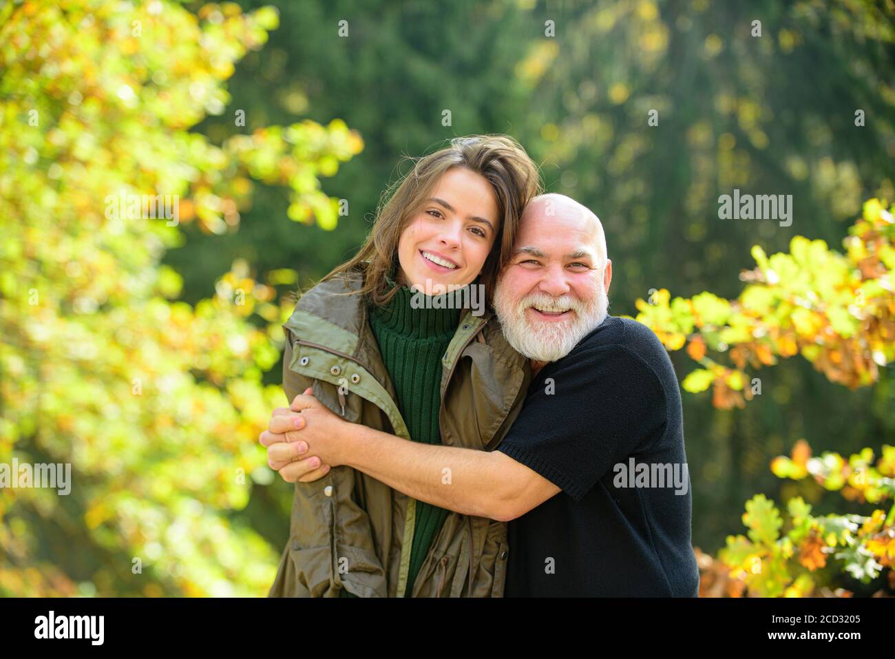 Autumn family. Loving grandfather hugging of adult granddaughter, hoary ...