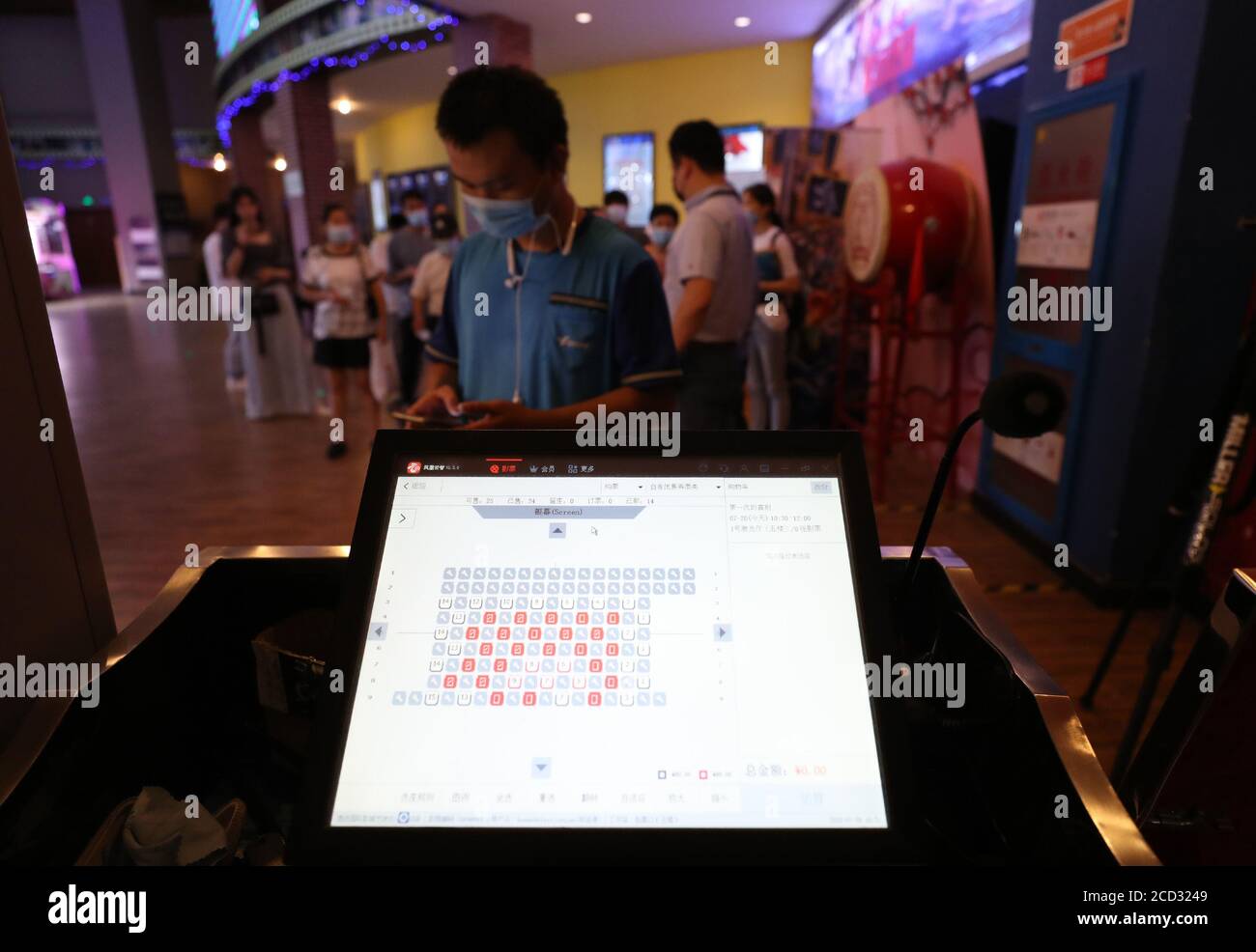 A large number of audience are seen in the cinema, purchasing tickets ...