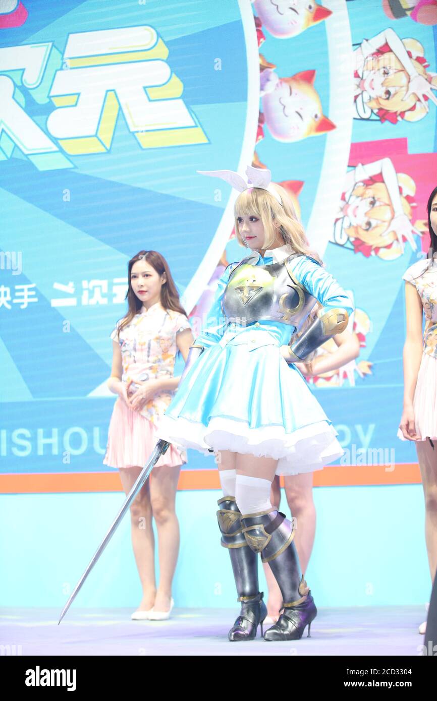 Beautiful cosplayers are seen posing and performing in clothes shown in ...