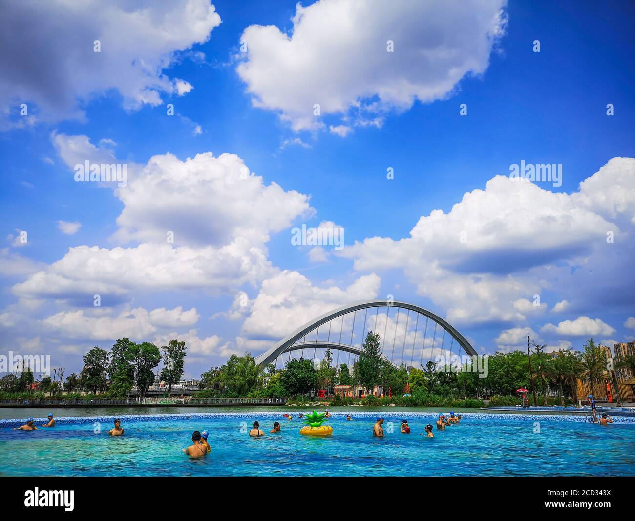 People swim at Sichuan's biggest outdoor swimming pool that is paved ...