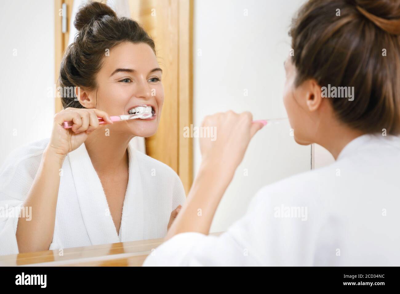 Woman cleaning her teeth in the bathroom Stock Photo - Alamy