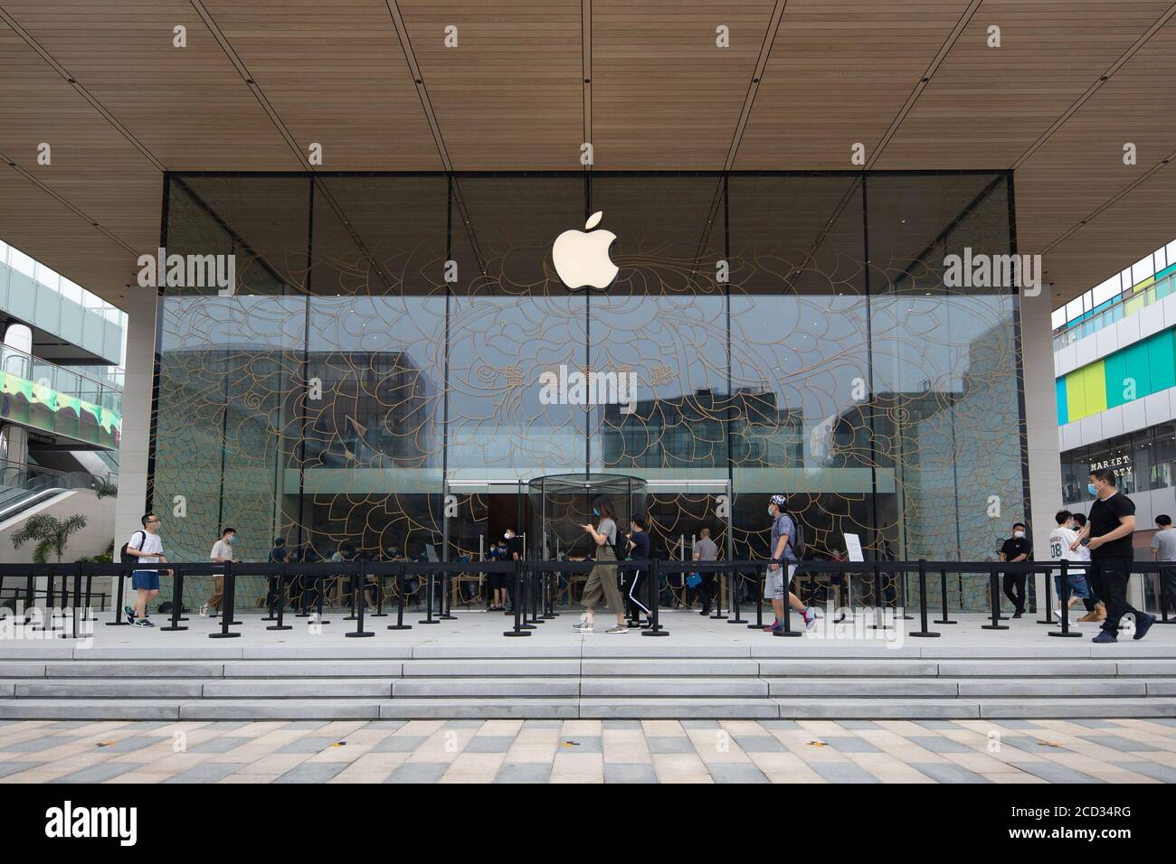 People line up to get inside the newly-opened Apple Store at Sanlitun ...