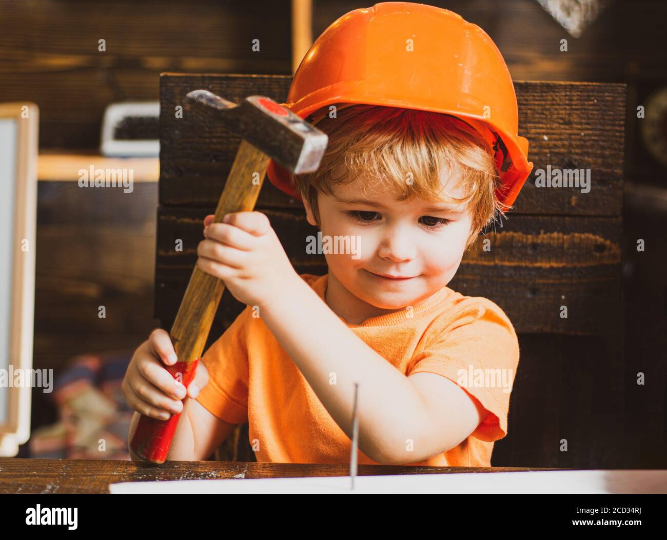 Little boy with a hammer makes repairs. Child is participating actively ...
