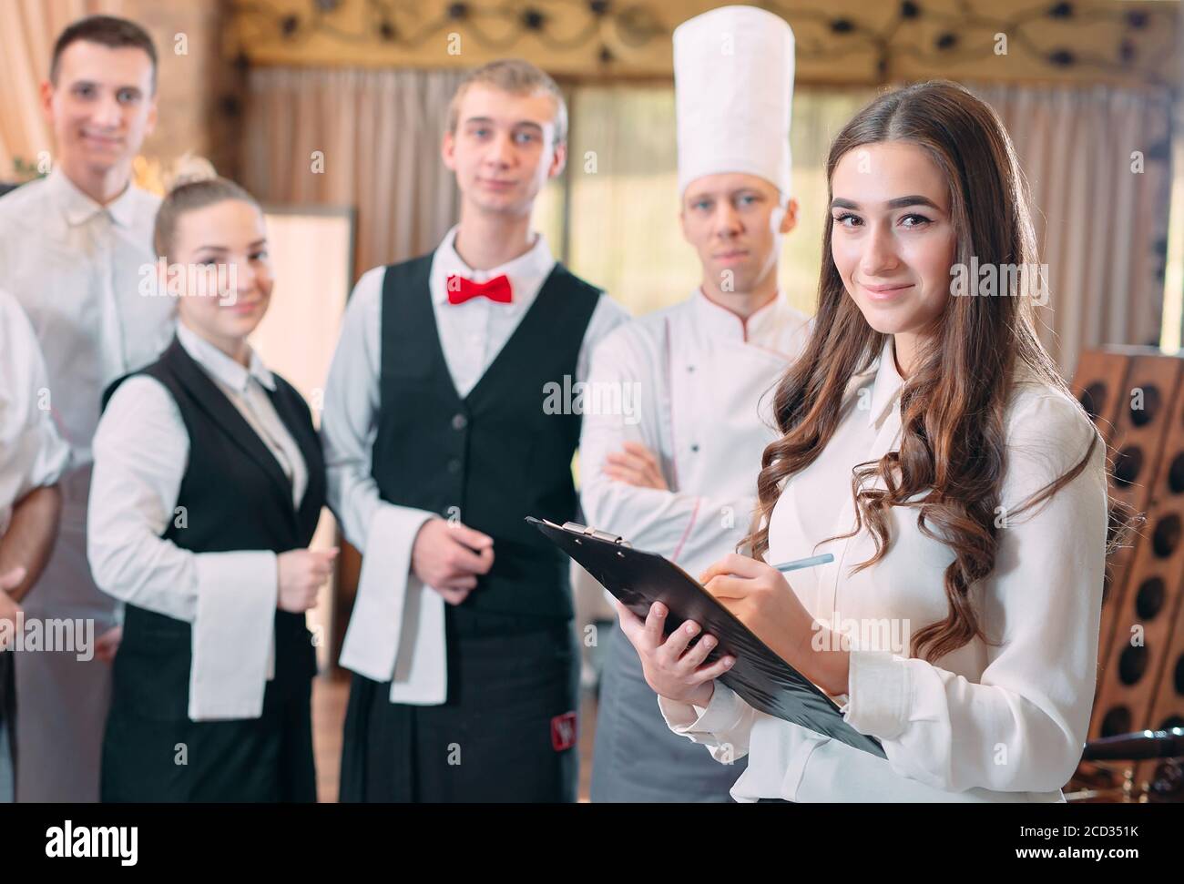restaurant manager and his staff in kitchen. interacting to head chef ...