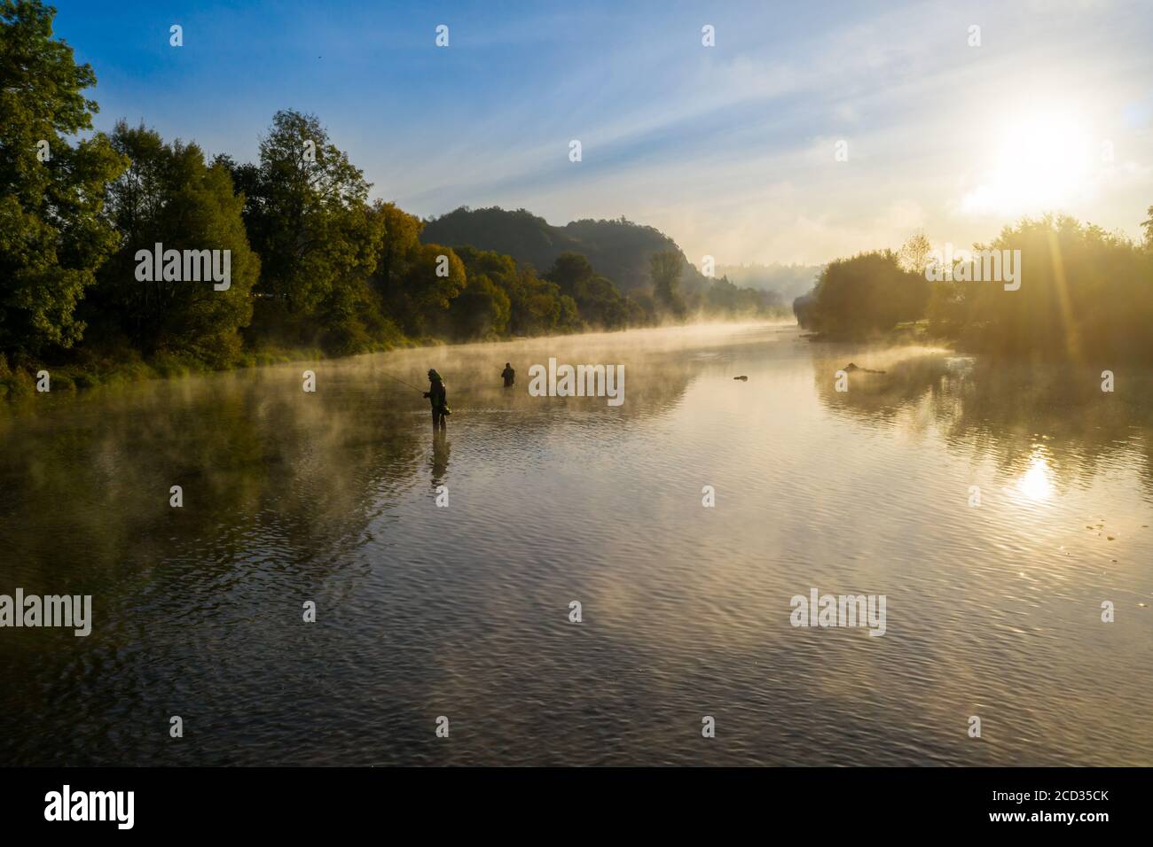 Aerial view of fishermen holding fishing rod, standing in river ...