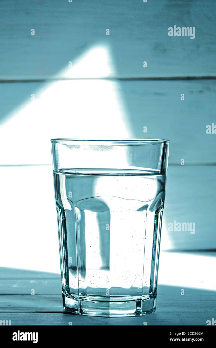Pure melt water in a glass stands on a white wooden background Stock ...