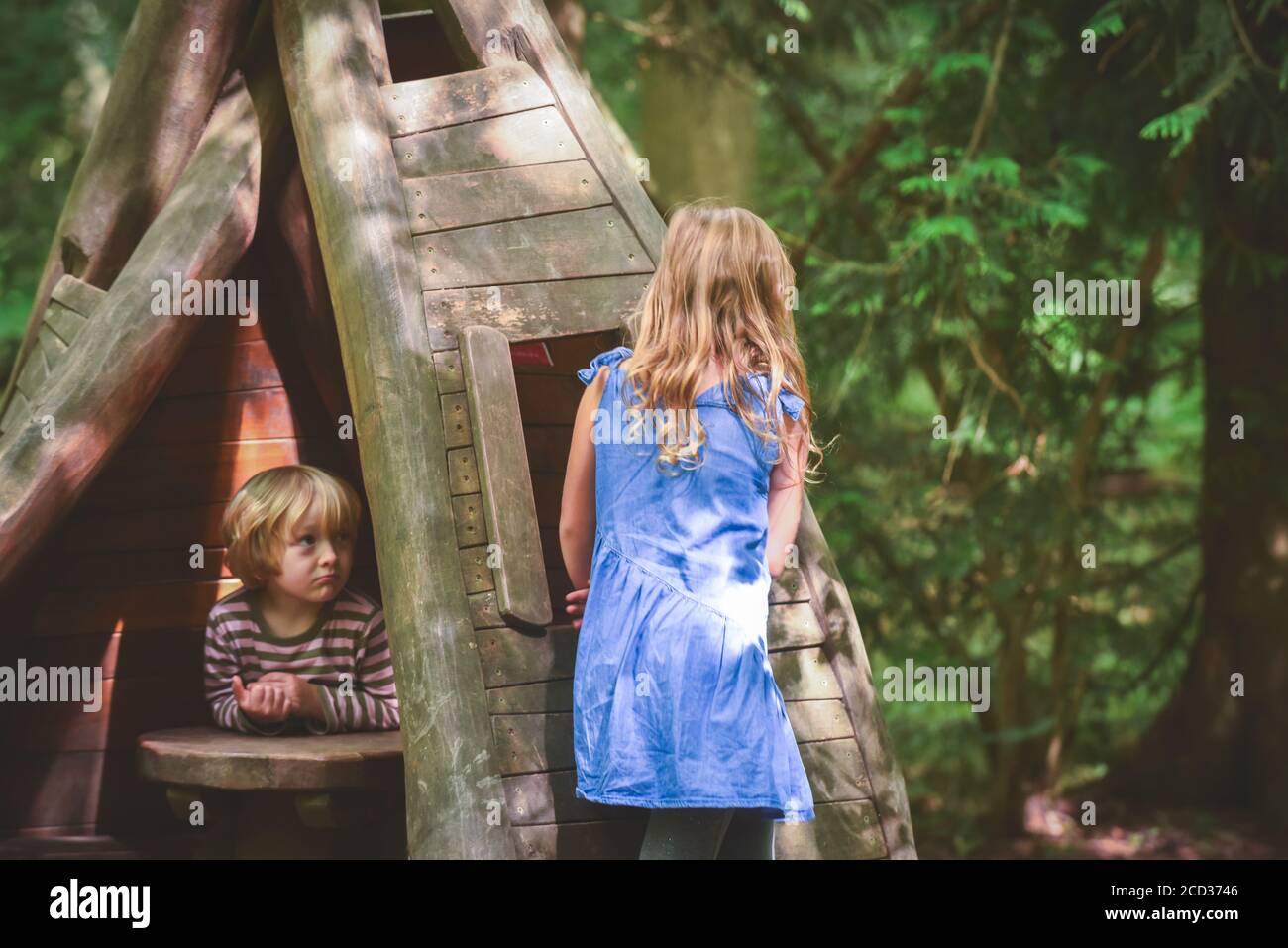 Kids playing outside at a play area with wooden toy house Stock Photo ...