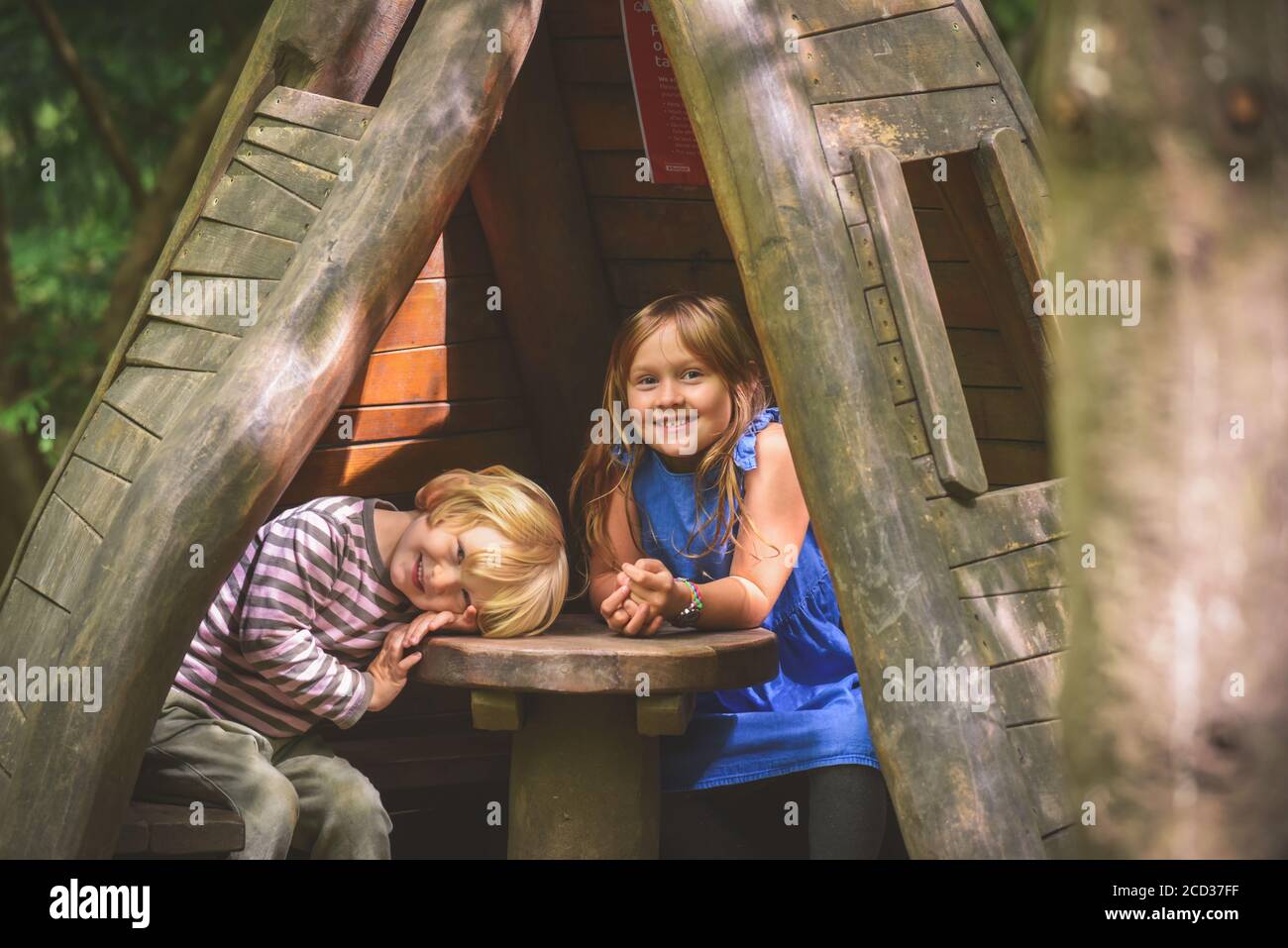 Kids playing outside at a play area with wooden toy house Stock Photo ...