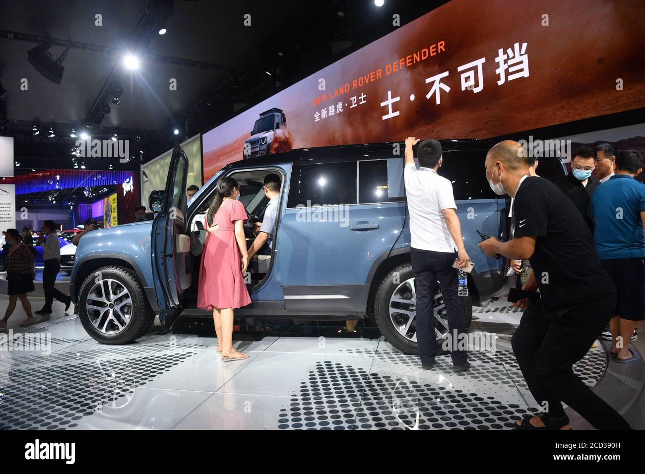 People try a Rover car exhibited at the opening ceremony of 2020 ...