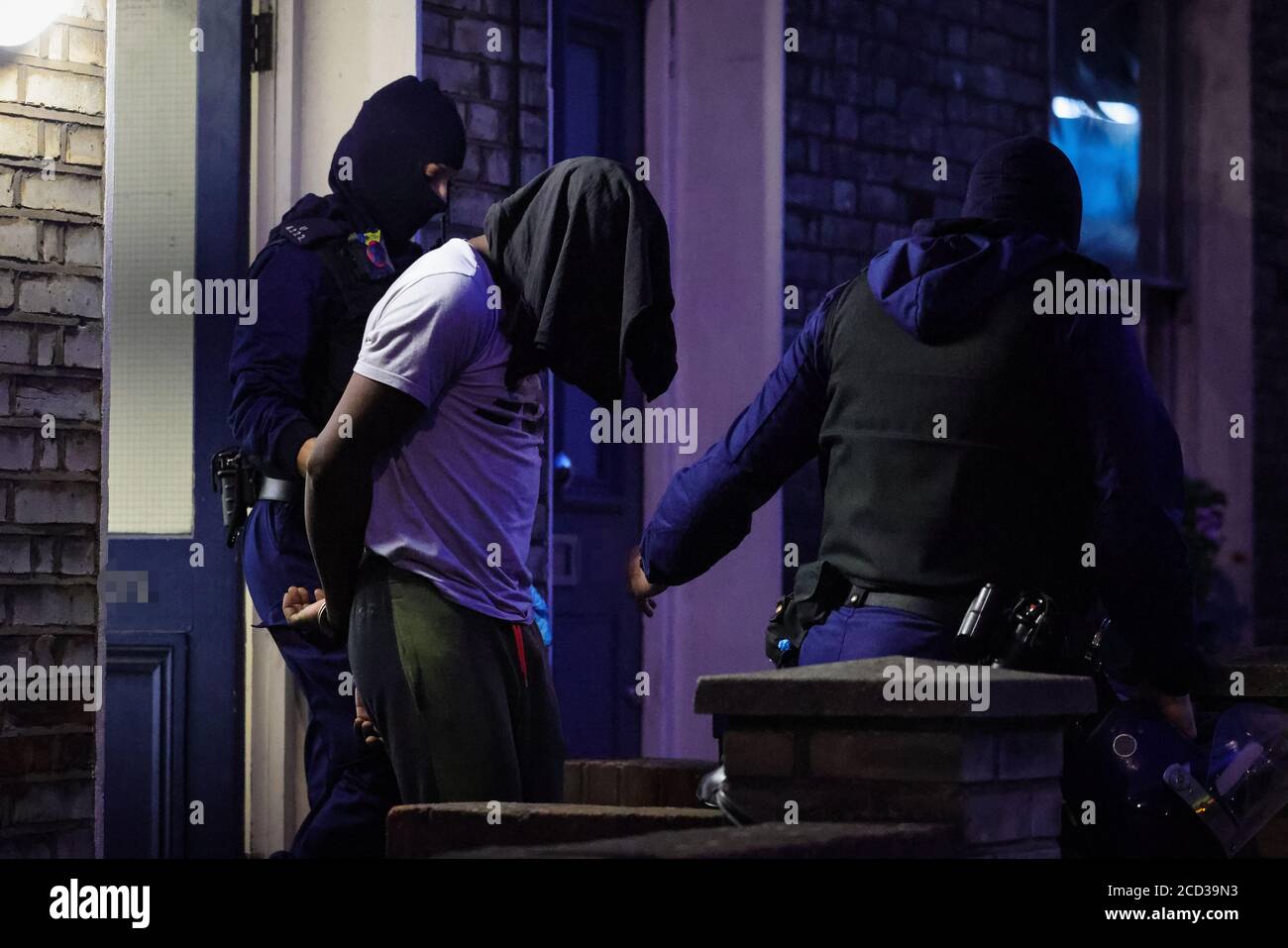 Metropolitan Police officers arrest an occupant of a property during a ...