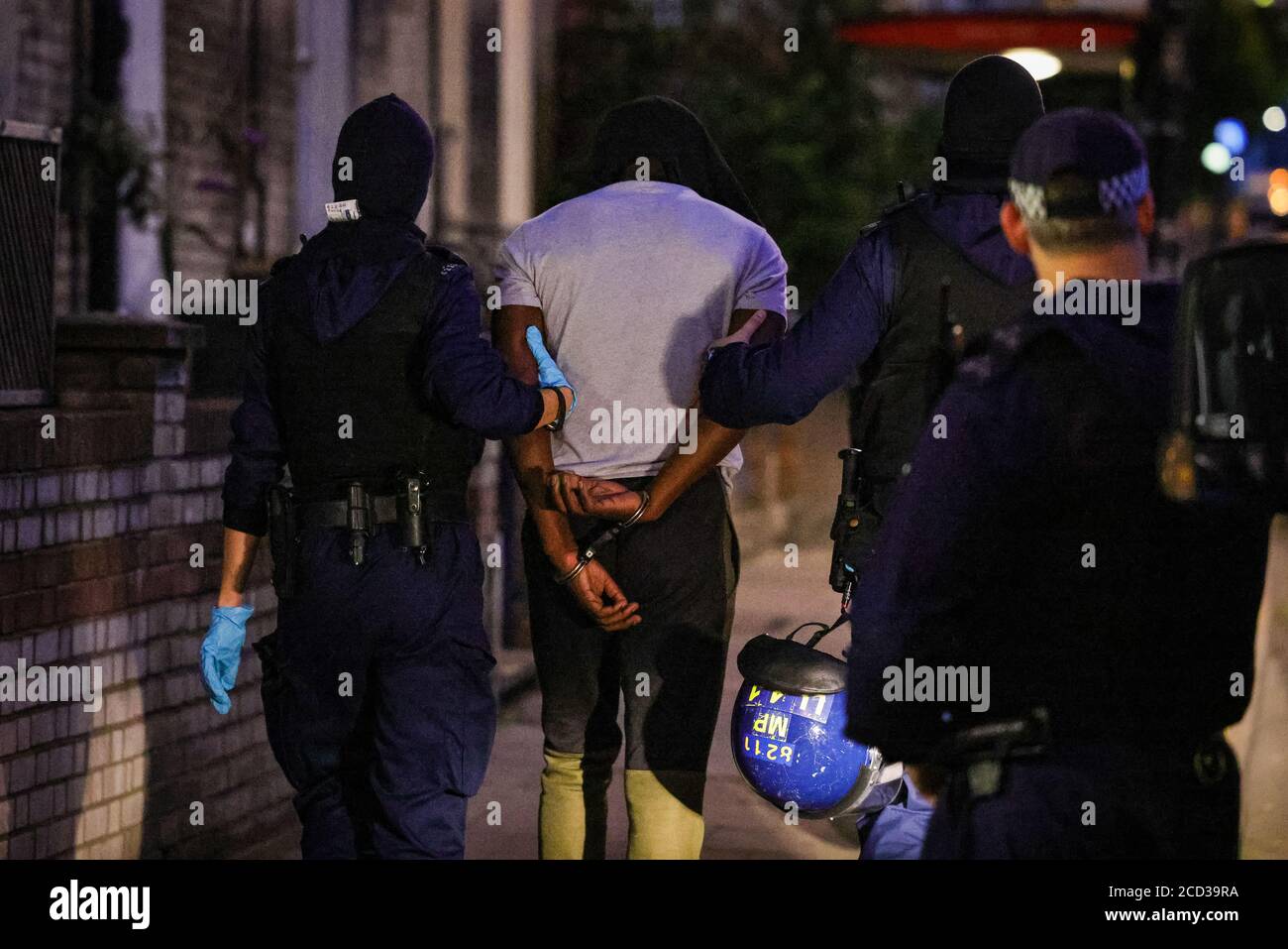 Metropolitan Police officers arrest an occupant of a property during a ...