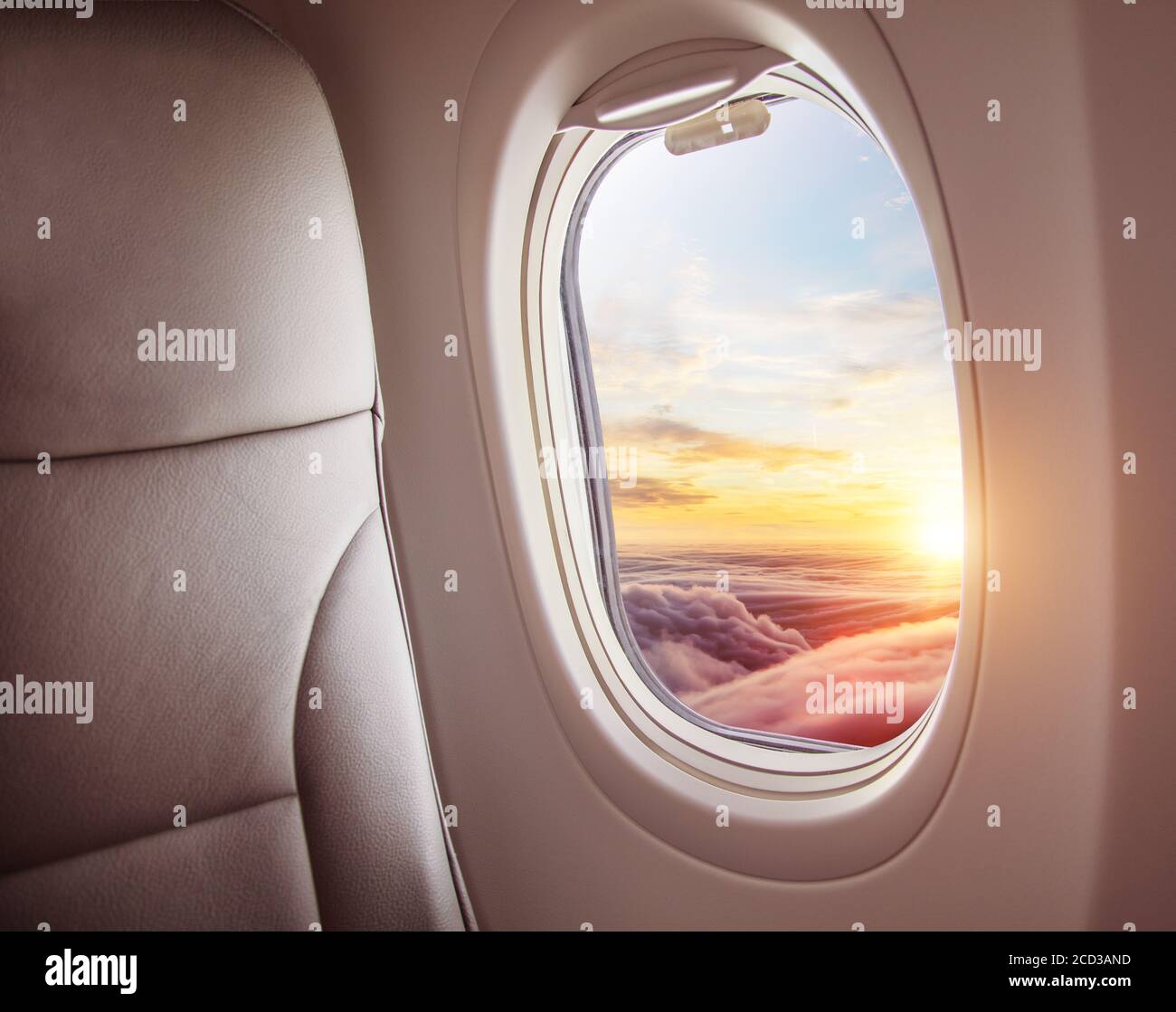 Airplane interior with window view of sunset above clouds. Concept of ...