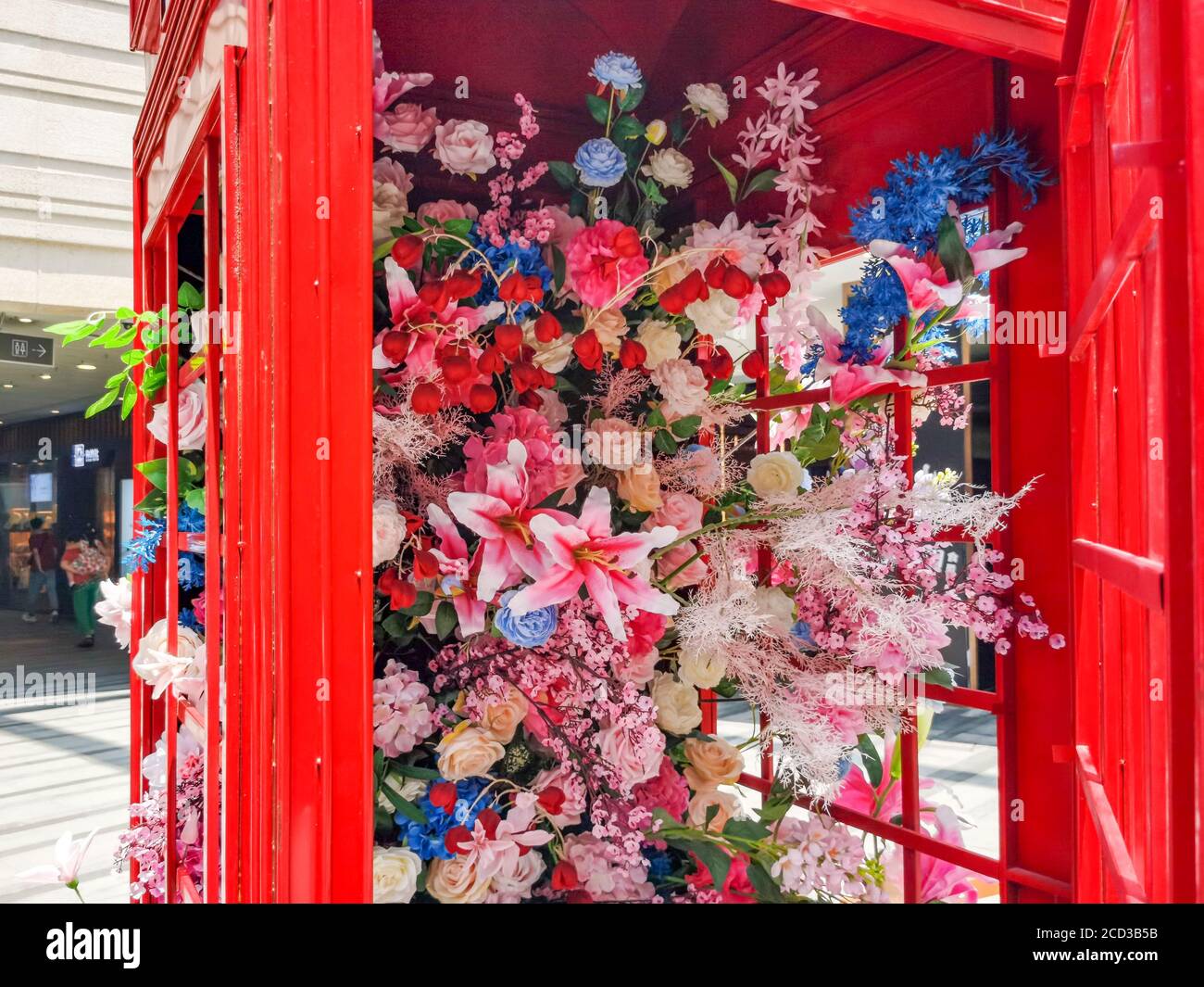 A phone booth, a trash bin and a Volkswagen Beetle fraught with flowers ...