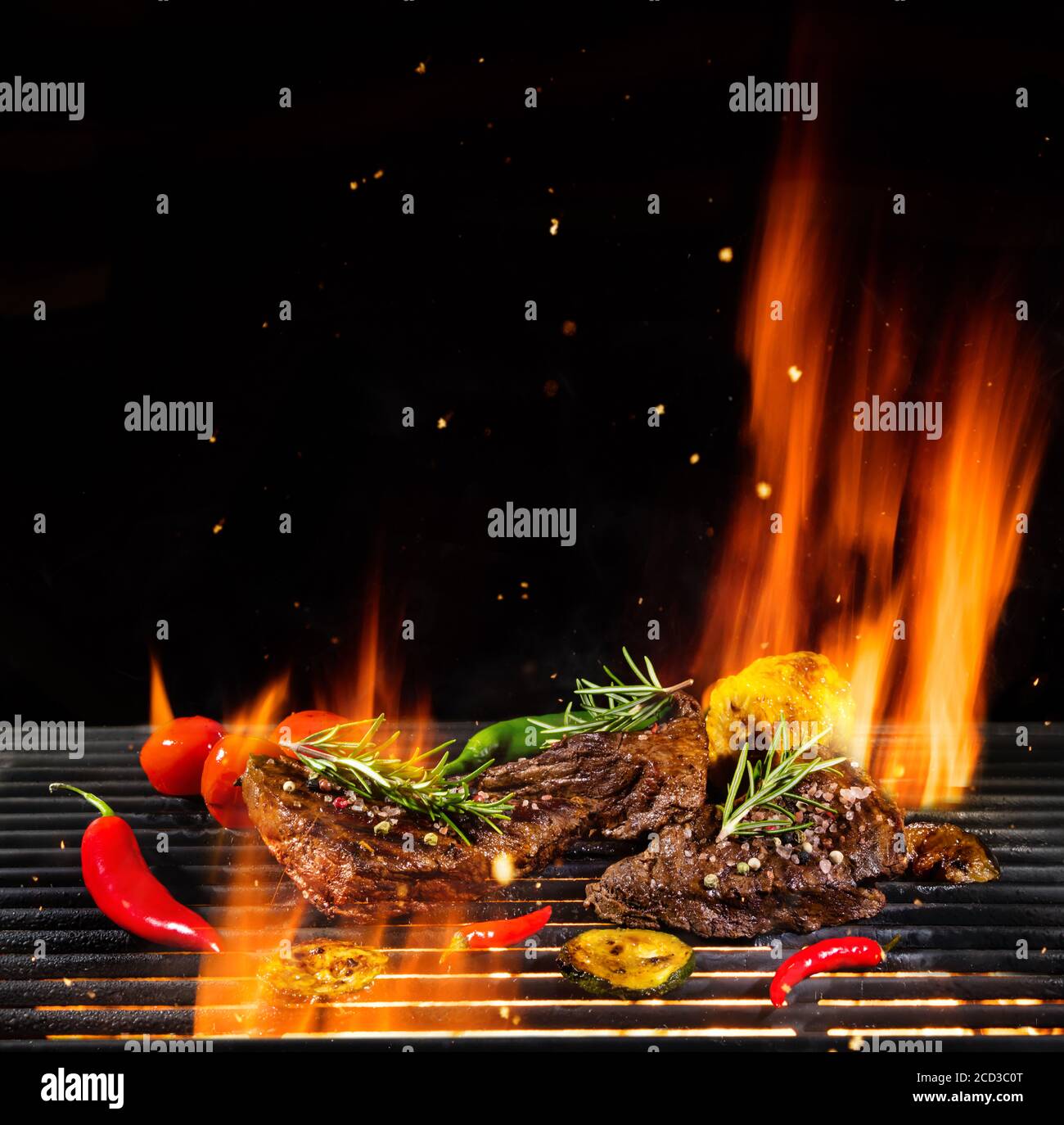 Delicious beef steaks on grill with Fire flames. Isolated on black ...