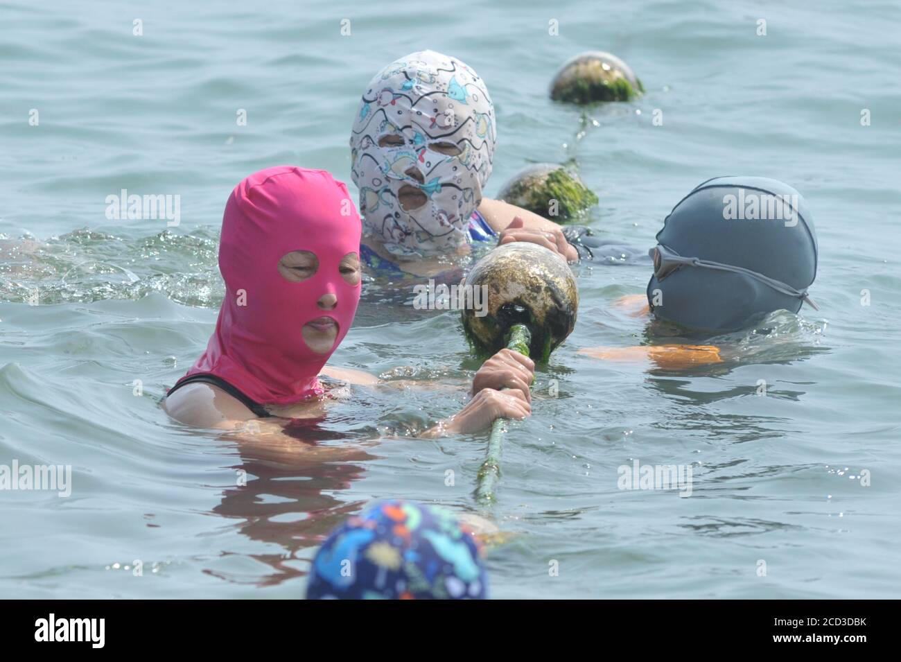 People enjoy beach and sunshine with facekini on, a mask designed for ...